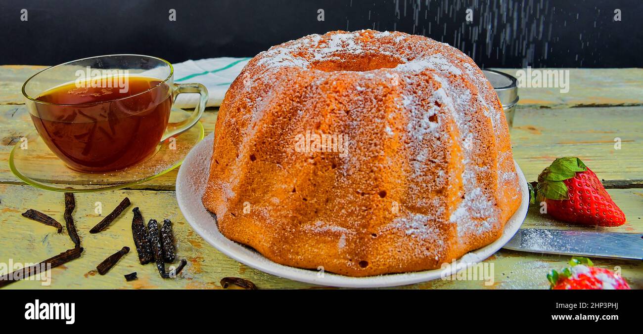Old fashioned sand cake with cup of black tea and pieces of vanilla on ...