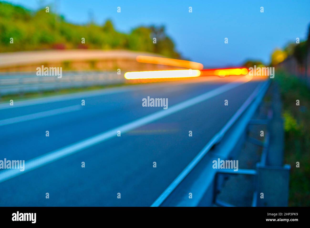 Highway at twilight with light trails. High traffic road with ...