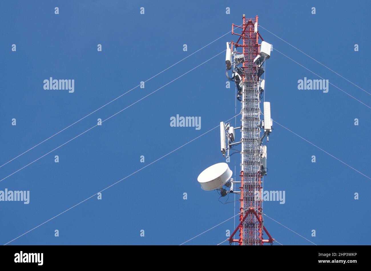 Internet towers and transmission equipment on clean blue sky background ...