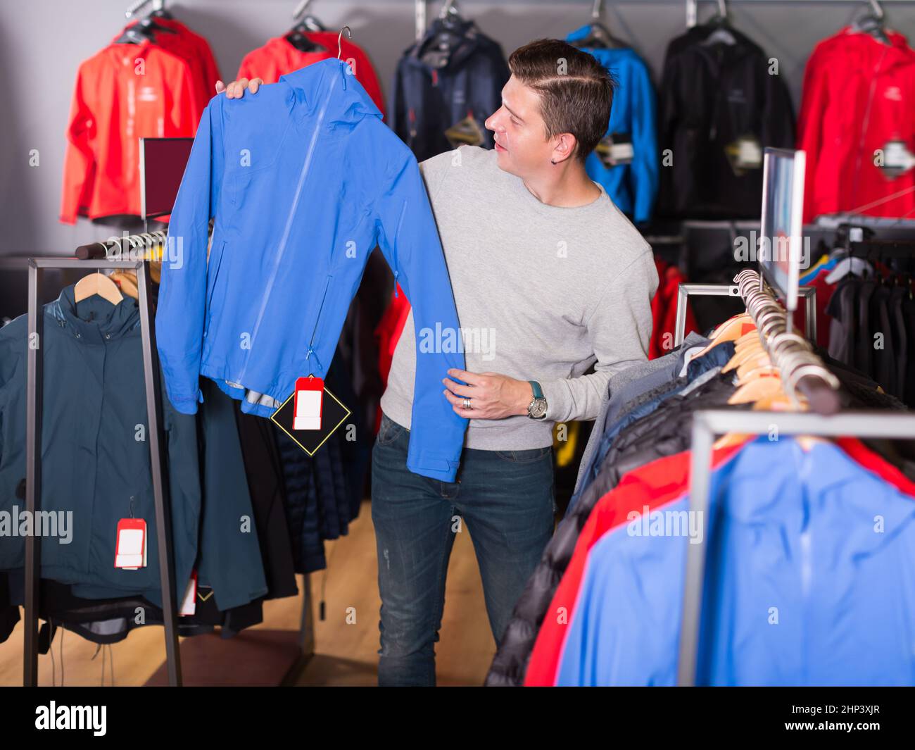 Glad man chooses clothes in shop Stock Photo - Alamy