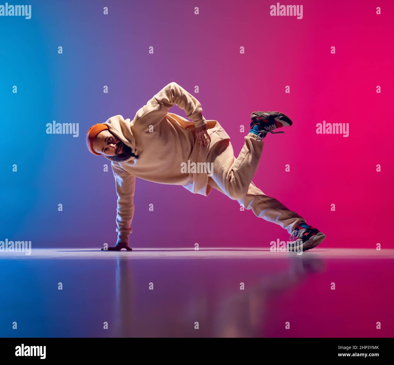 Studio shot of young flexible sportive man dancing breakdance in white ...