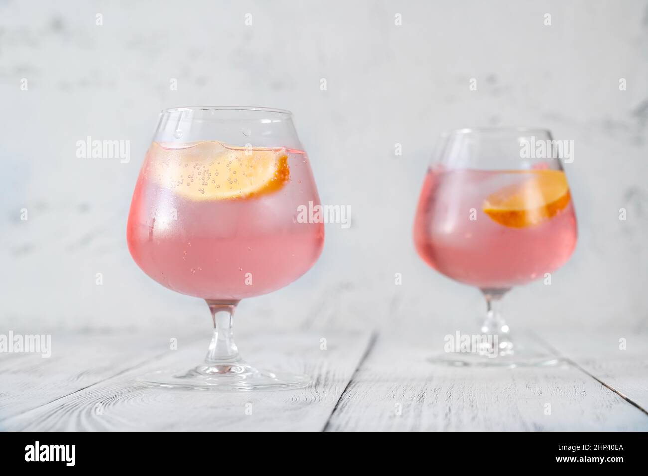 Pink vodka lemonade cocktail garnished with lemon wedge Stock Photo - Alamy
