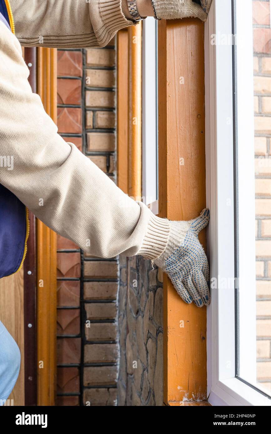 gluing protective decorative corner to frame of plastic window on ...