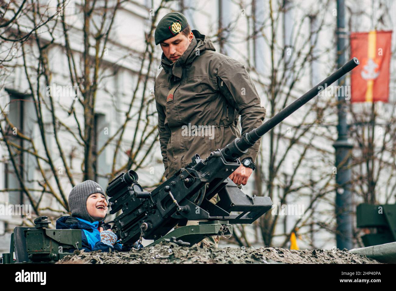 Kid or child smiling and playing on the top of a tank or military ...