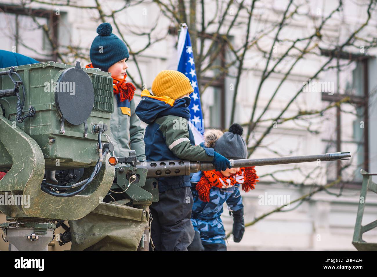 Kids or children playing like soldiers on the top of a tank or military ...