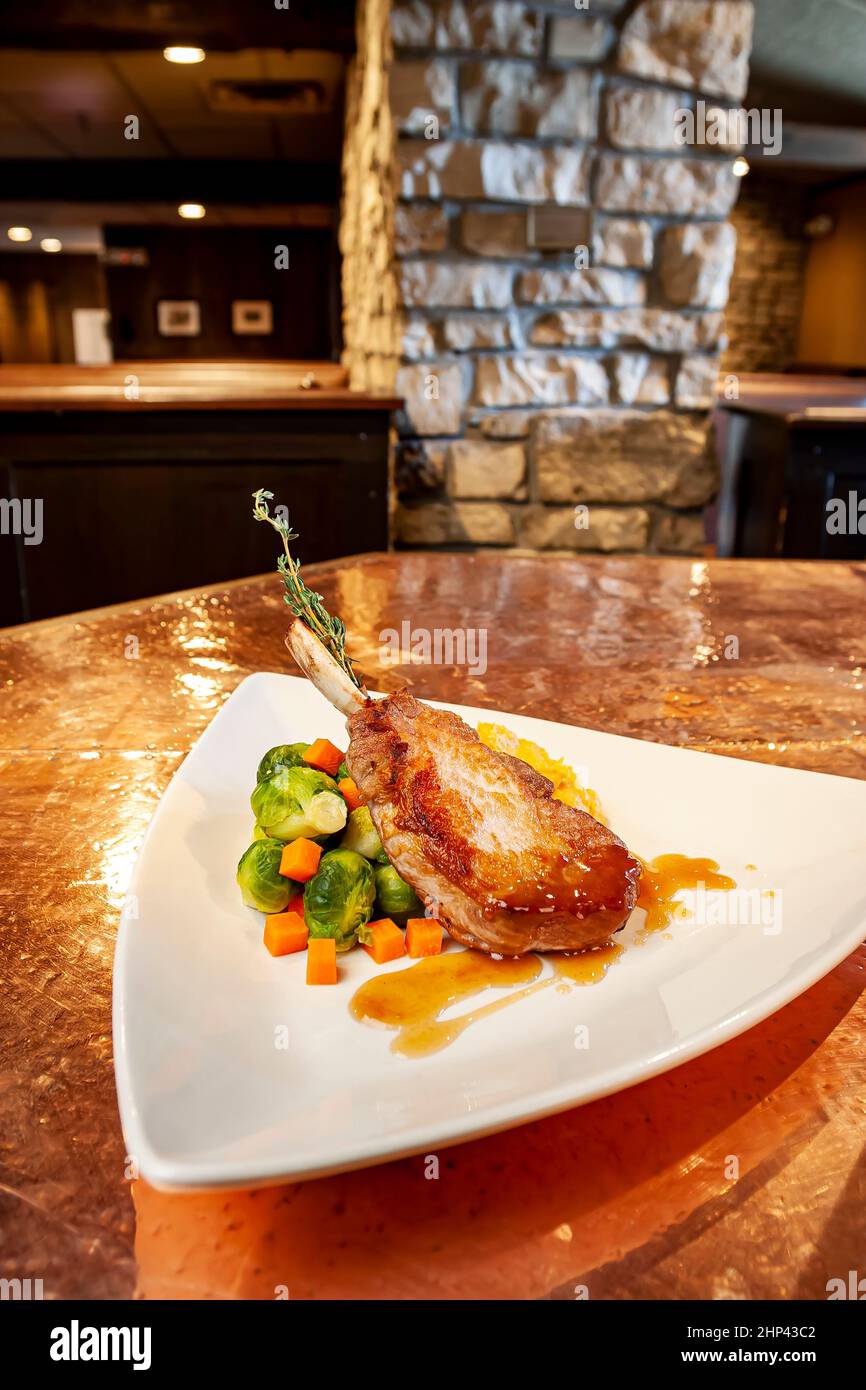 A savory pork chop entree sits on a copper clad table Stock Photo - Alamy
