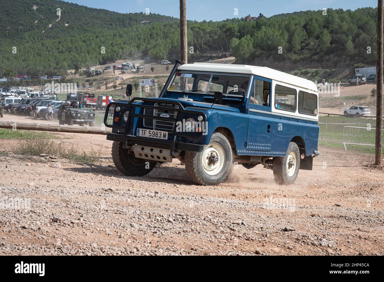 Close-up shot of a man driving a blue Land Rover Santana Series III ...