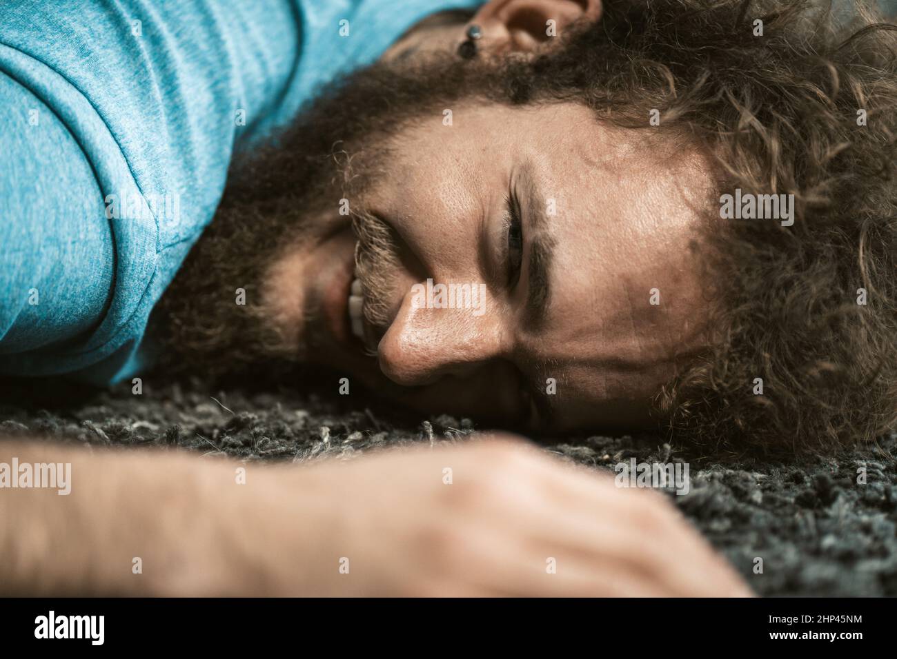 Happy exhausted home exercise man laying on the carpet and resting ...