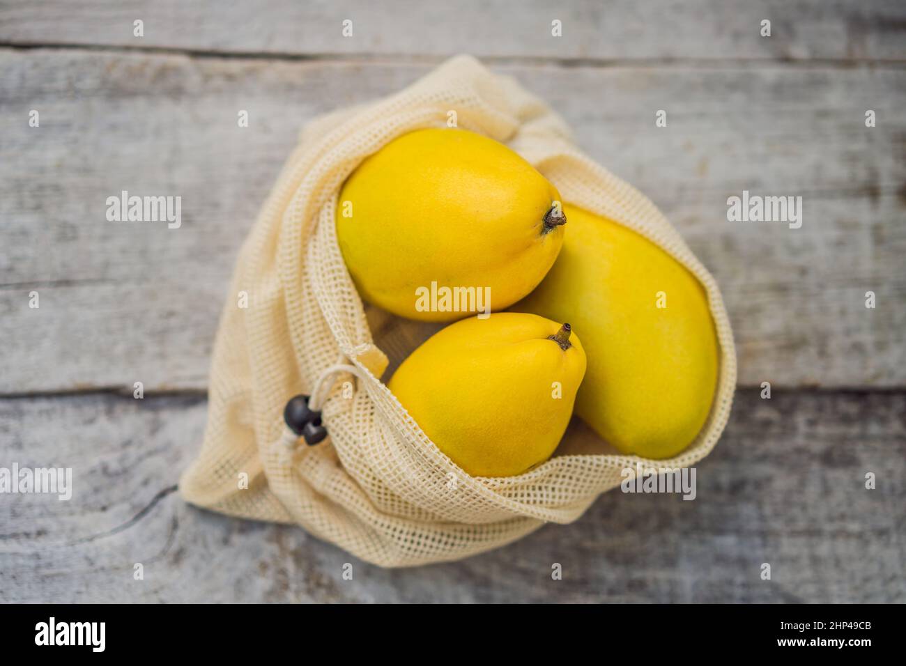 Mango in a reusable bag on a stylish wooden kitchen surface. Zero waste ...