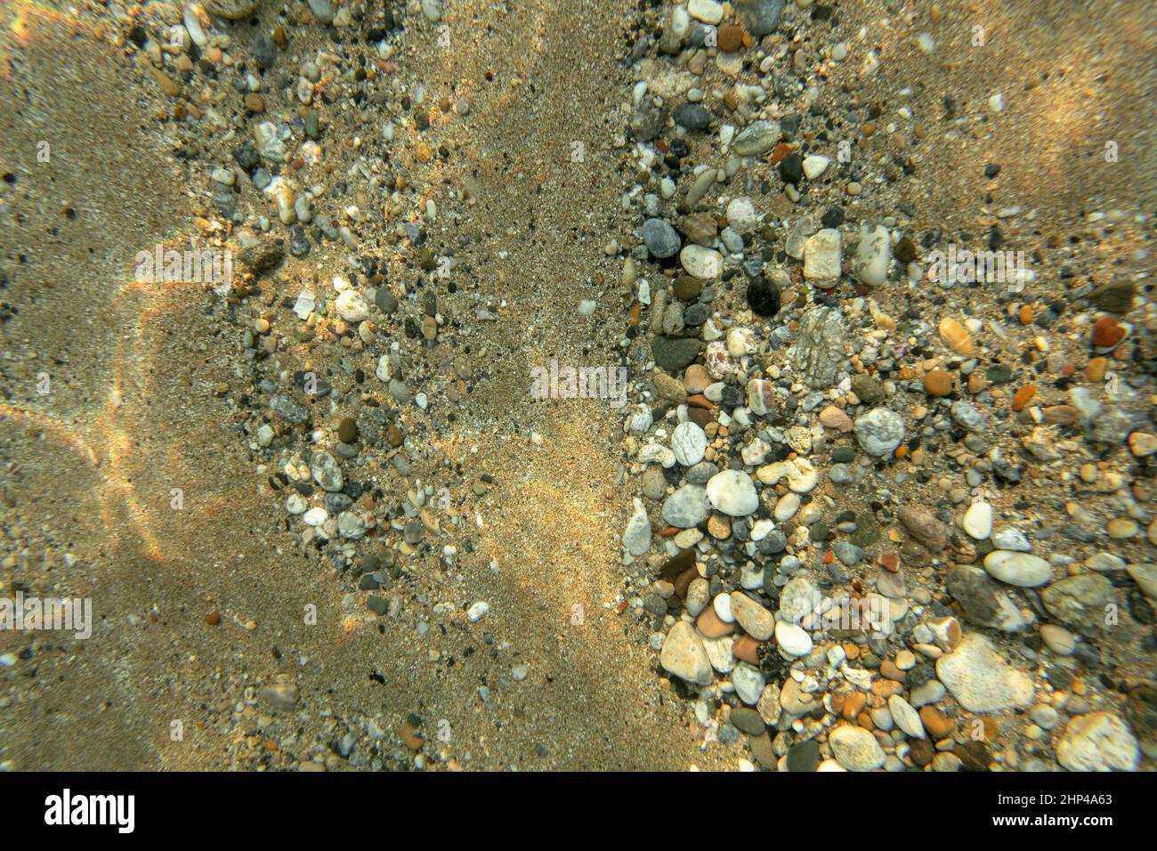 Underwater photo - sand sea bottom with small pebbles and stones, lit ...