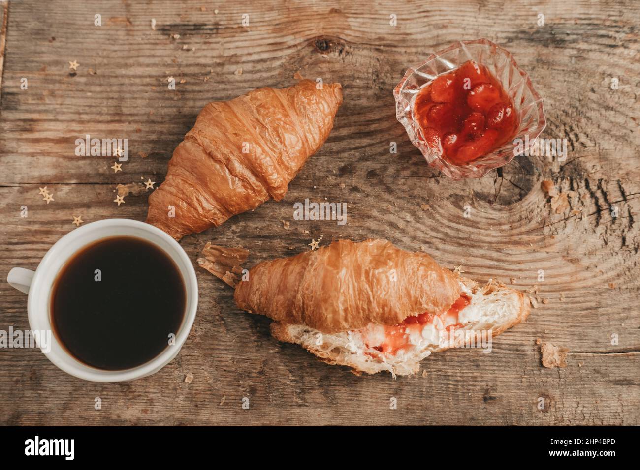 cut croissant with butter and strawberry jam with a cup of coffee, on a ...