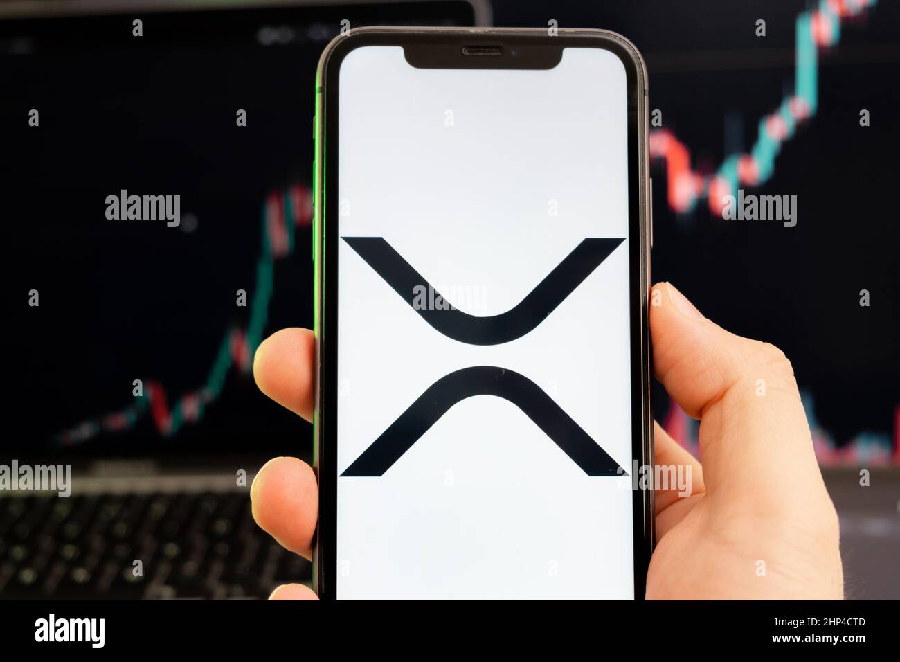 XRP cryptocurrency logo on the screen of a smartphone in mans hand with ...