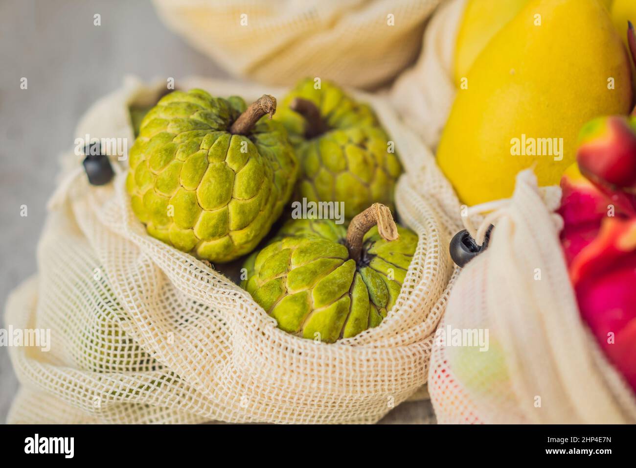 Fruit in a reusable bag on a stylish wooden kitchen surface. Zero waste ...