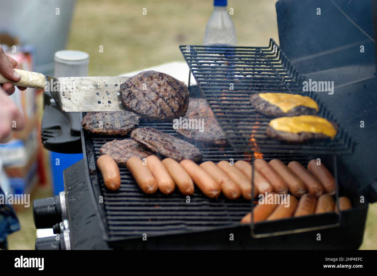 Hamburgers and Hotdogs cooking on Bar-B-Q at Club cookout for kids and ...