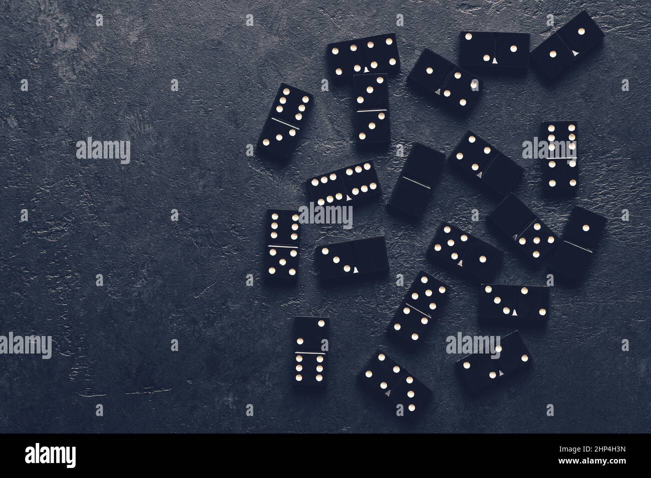 Old black domino chips scattered around the table in vintage style ...