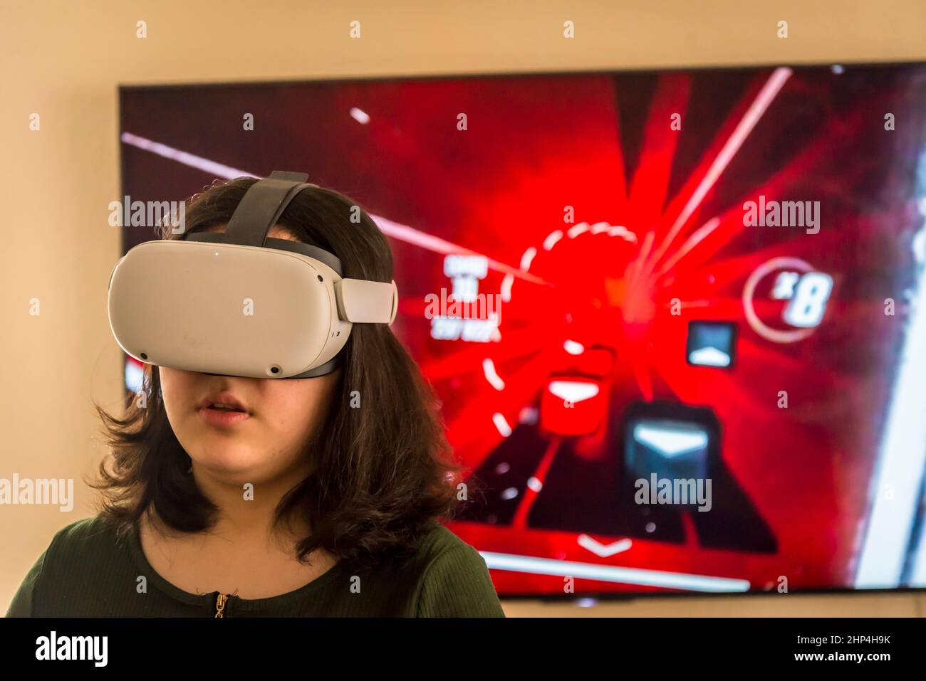 Girl with VR headset playing with friends in virtual reality and ...