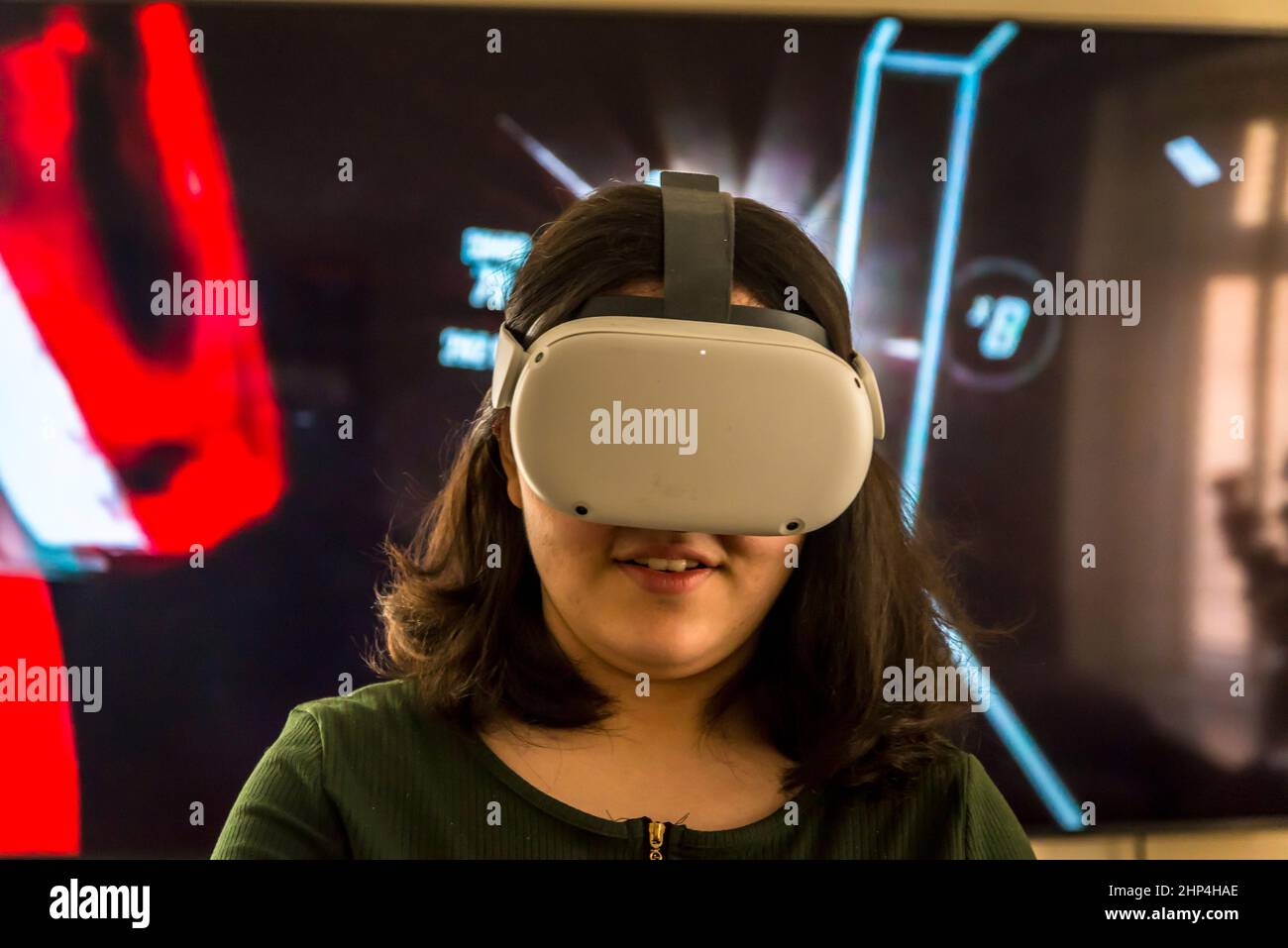 Girl with VR headset playing with friends in virtual reality and ...