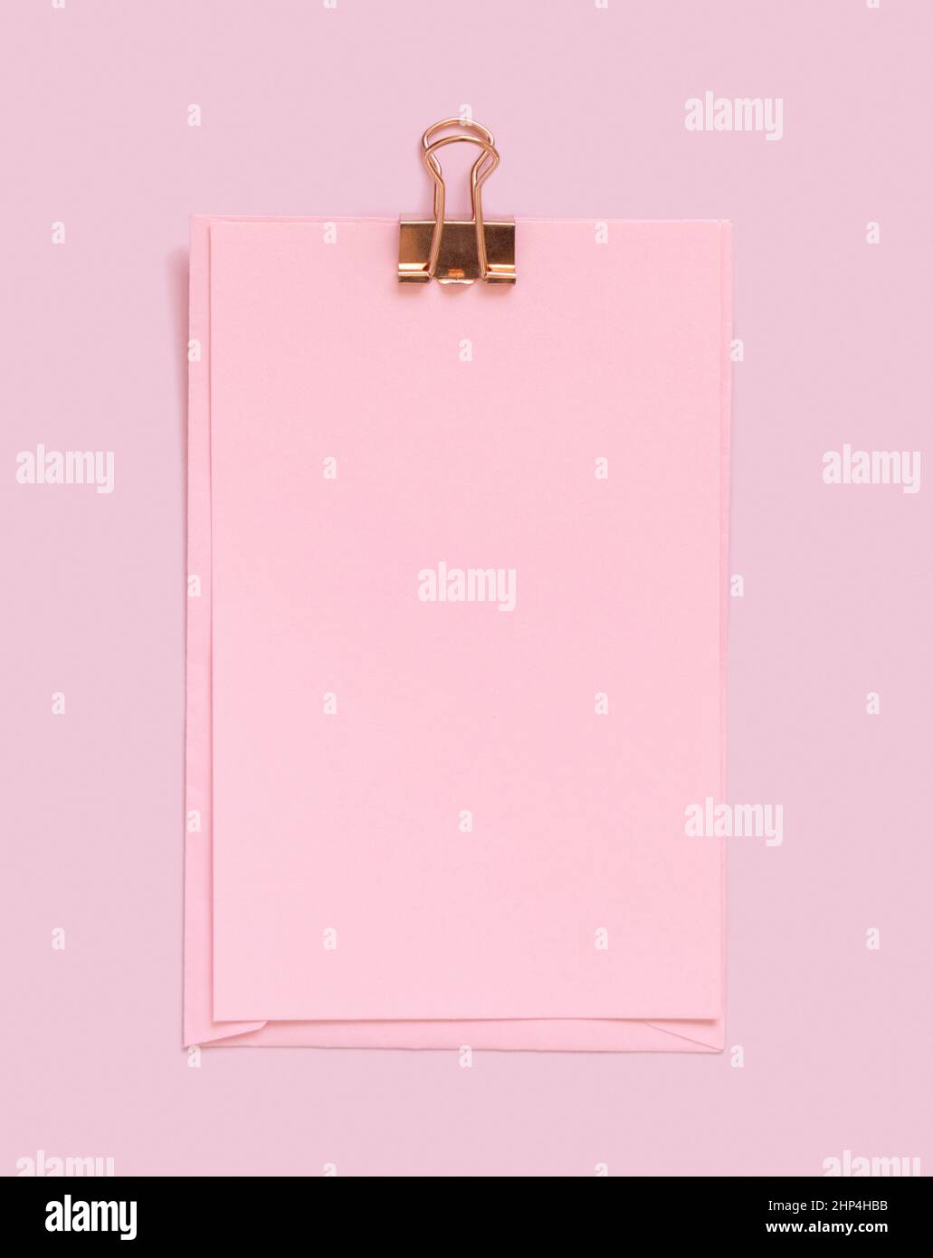 Pink paper card with clip on pink top view. Minimal scene with blank ...