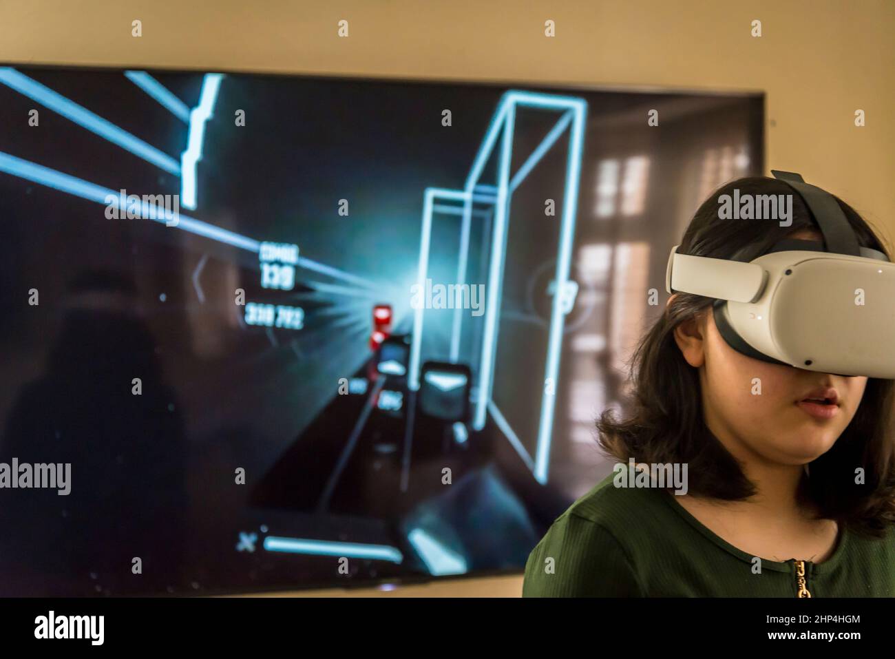 Girl with VR headset playing with friends in virtual reality and ...
