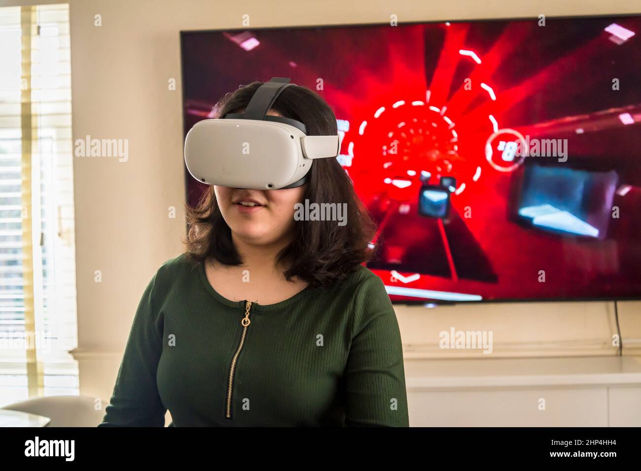 Girl with VR headset playing with friends in virtual reality and ...