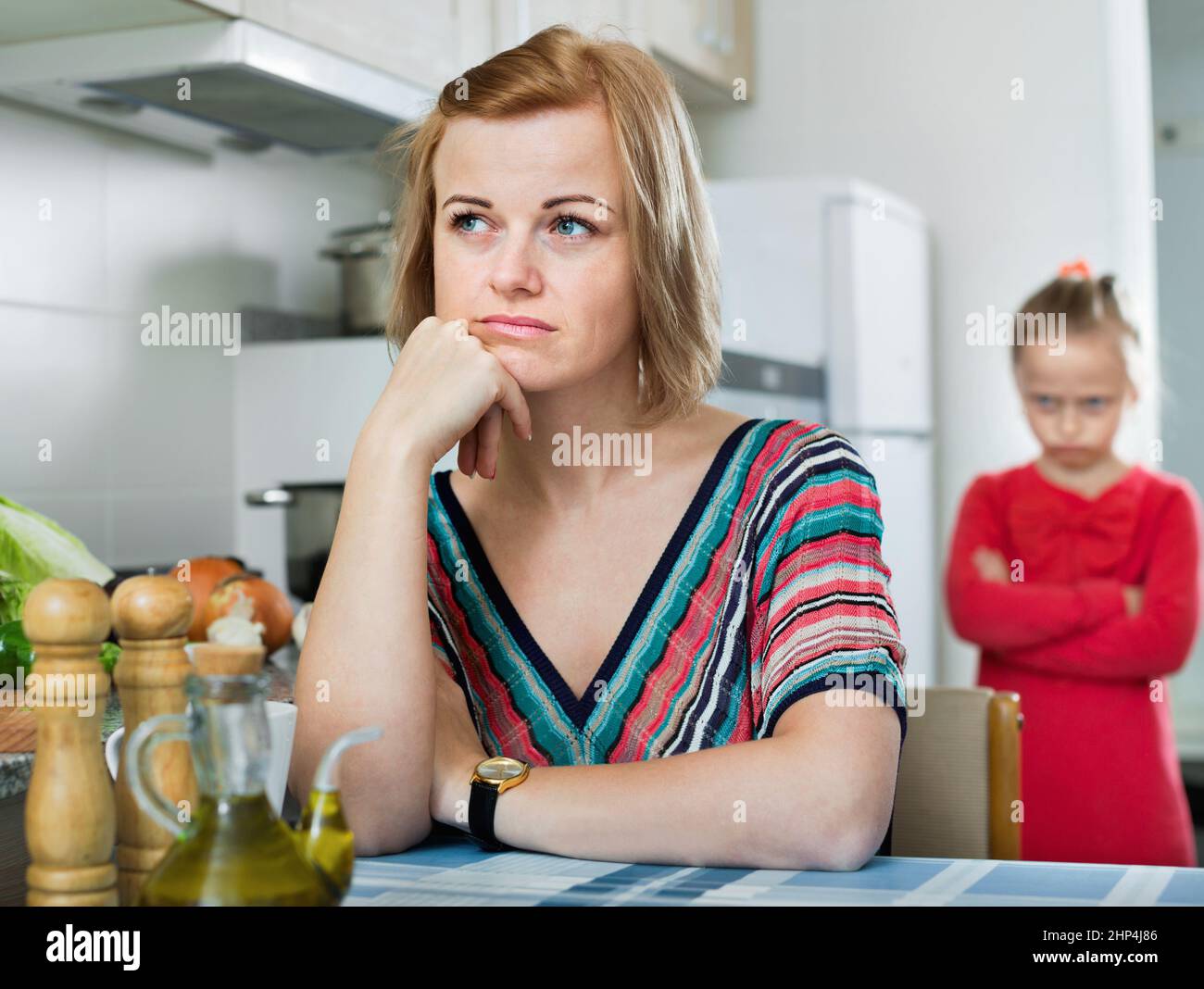 Upset girl and mother have a peeve on each other Stock Photo - Alamy