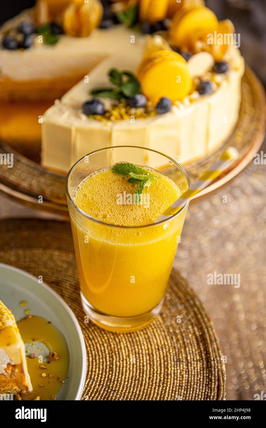Glass of orange juice stand near a cake at bakery shop Stock Photo - Alamy