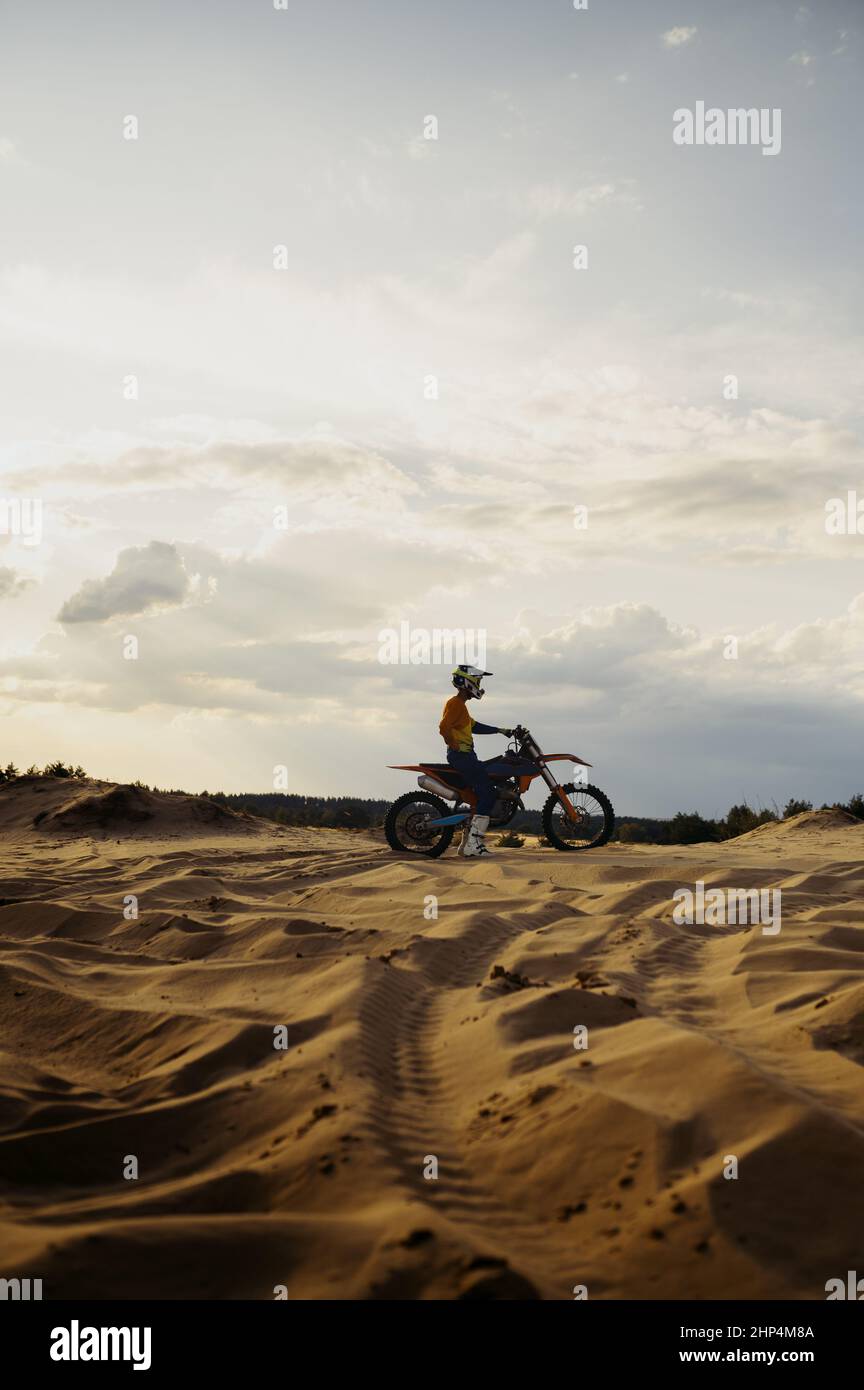 Motorcross riding over sand in desert dune. Professional bike pilot ...