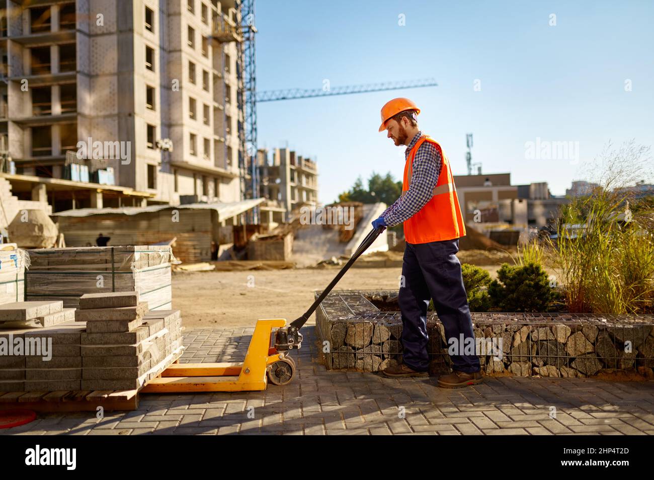 Male worker making concrete at construction site. Builder using shovel ...