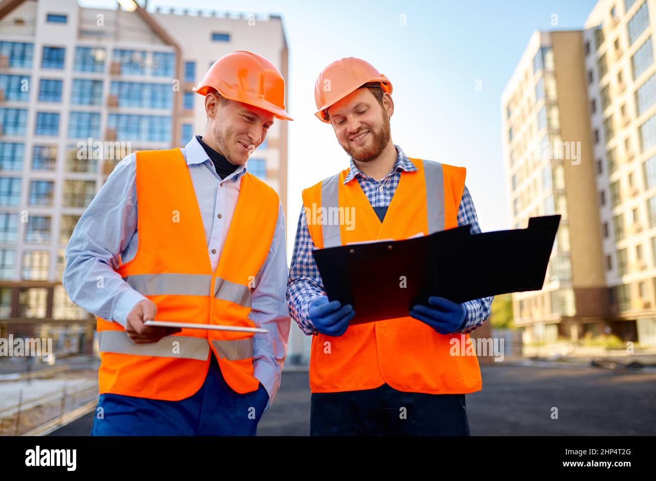 Smiling construction workers discussing floor plan. Main engineer ...