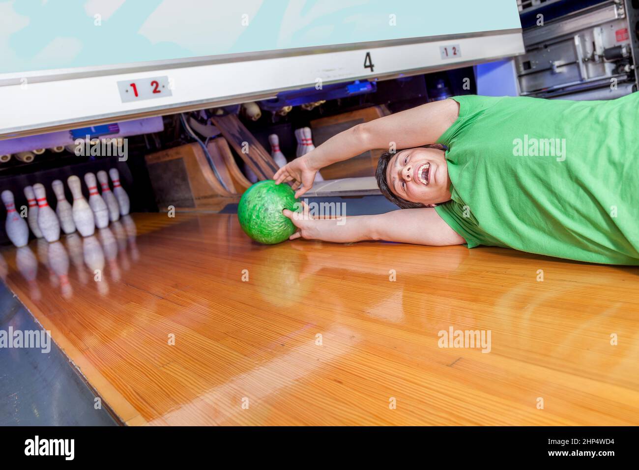 young man sliding down a bowling alley Stock Photo - Alamy