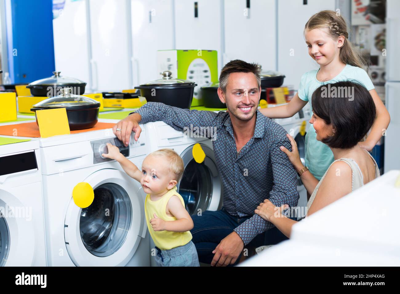 Adult family with kids choosing washing machine Stock Photo - Alamy