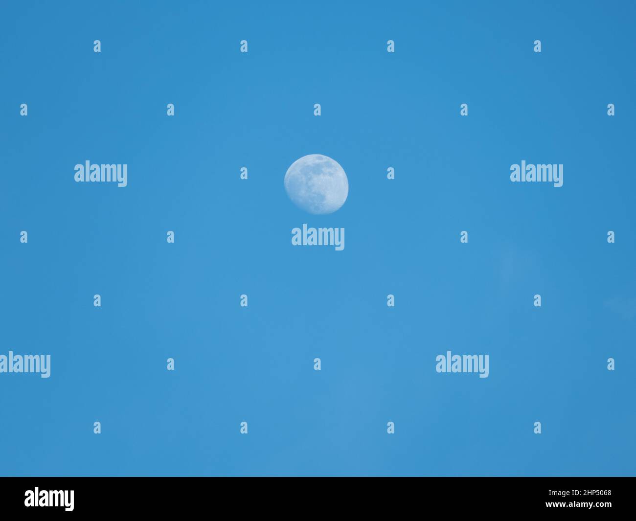Moon setting into the clouds in daytime Stock Photo - Alamy