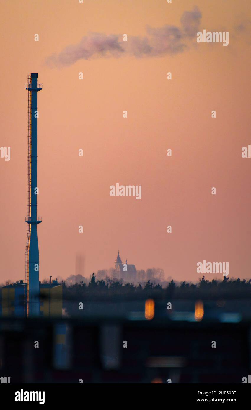 Vertical shot of an industrial building on the sunset sky background ...
