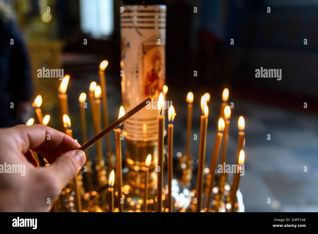 Candles in Russian orthodox cathedral with icons on background. Hand ...