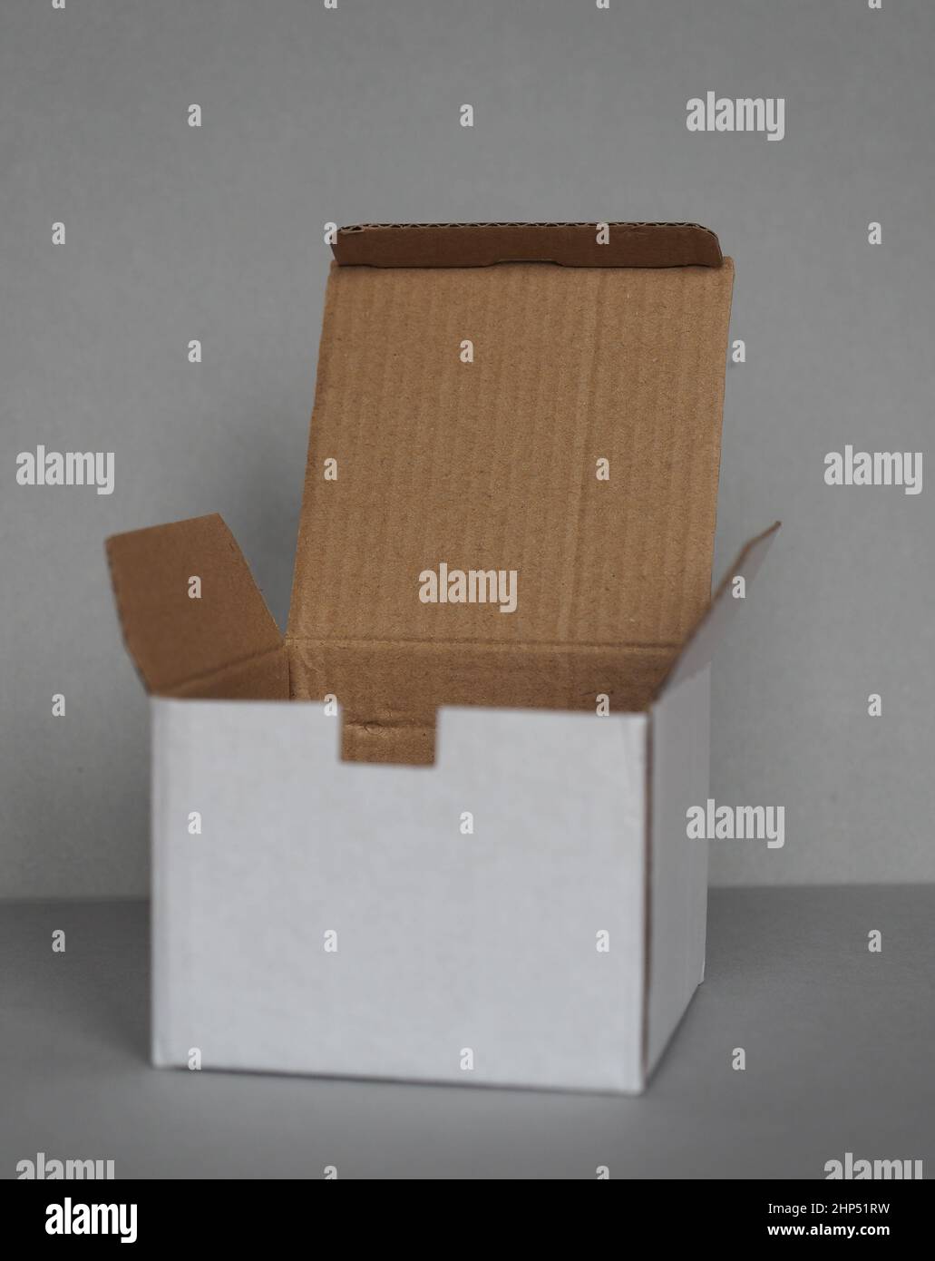 empty cardboard box in front of grey wall Stock Photo - Alamy