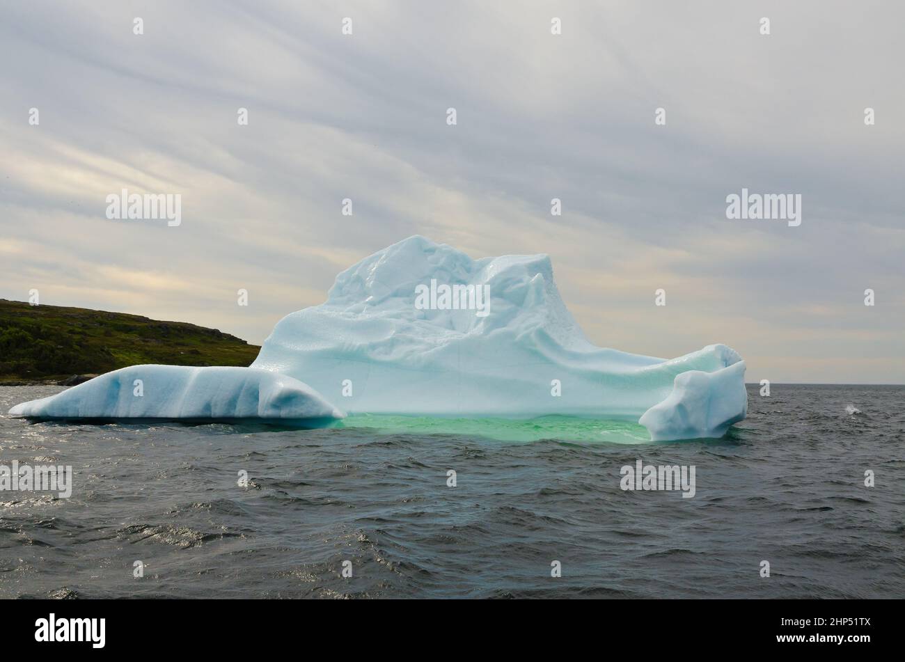 Bright white iceberg on dark water and rock background Stock Photo - Alamy