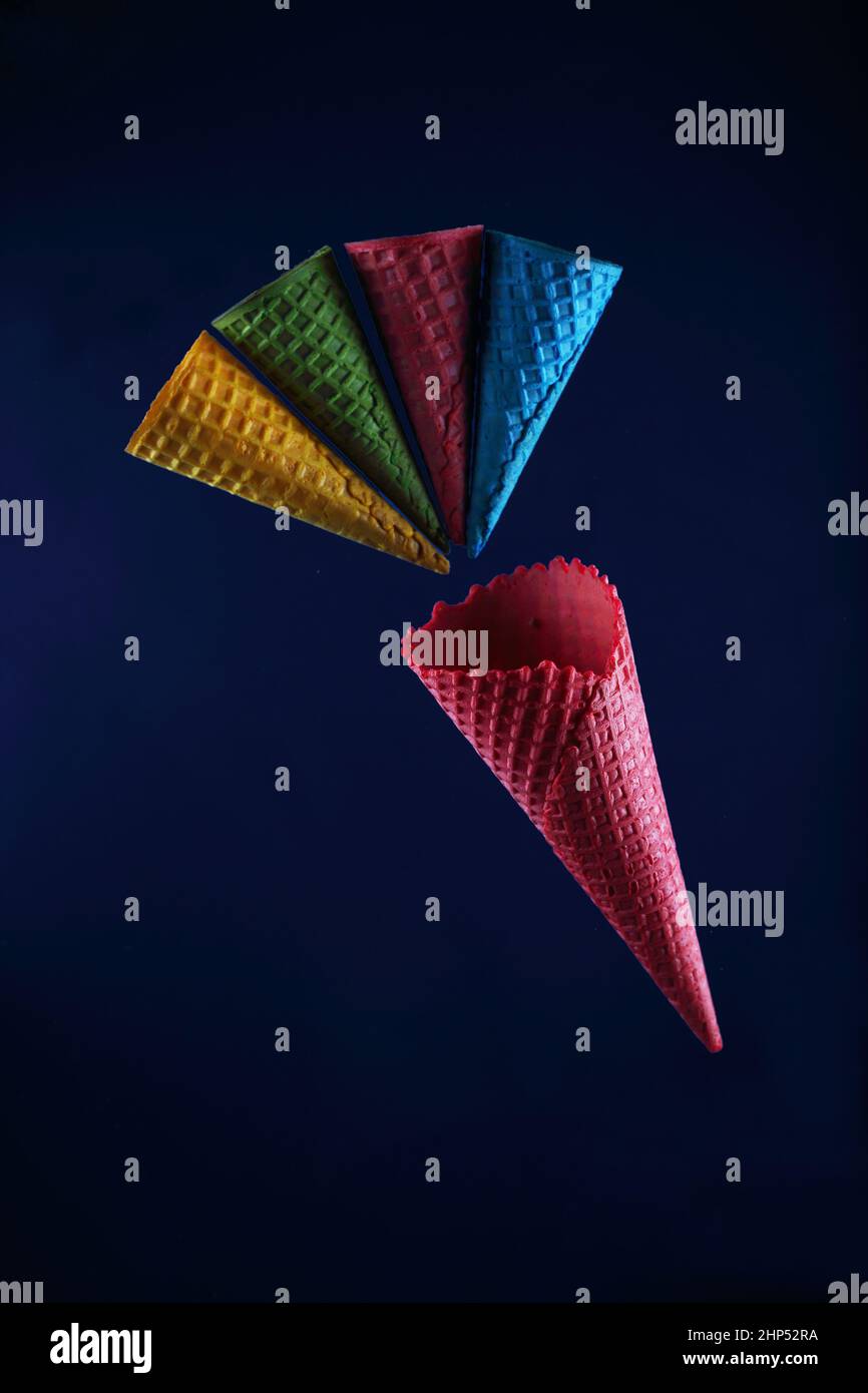 four waffle cones of different colours isolated against blue background ...