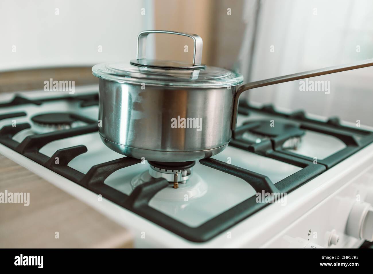 Close up image of stainless steel pot on gas stove with kitchen timer ...