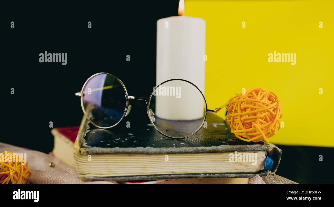 Eyeglasses on old books. Glasses on stack of books on black and yellow ...