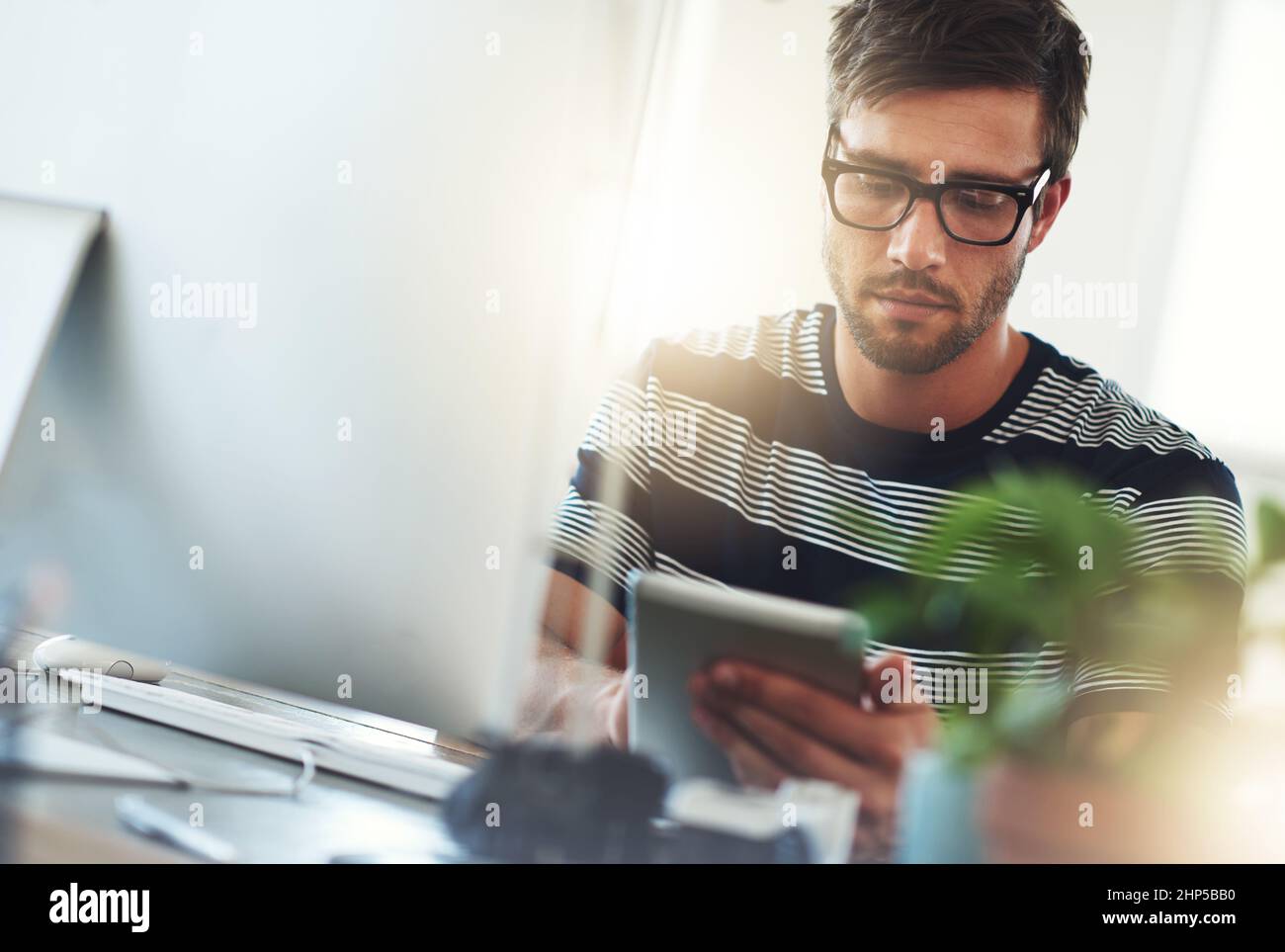 Hes a design pro at work. Shot of a designer using his digital tablet ...