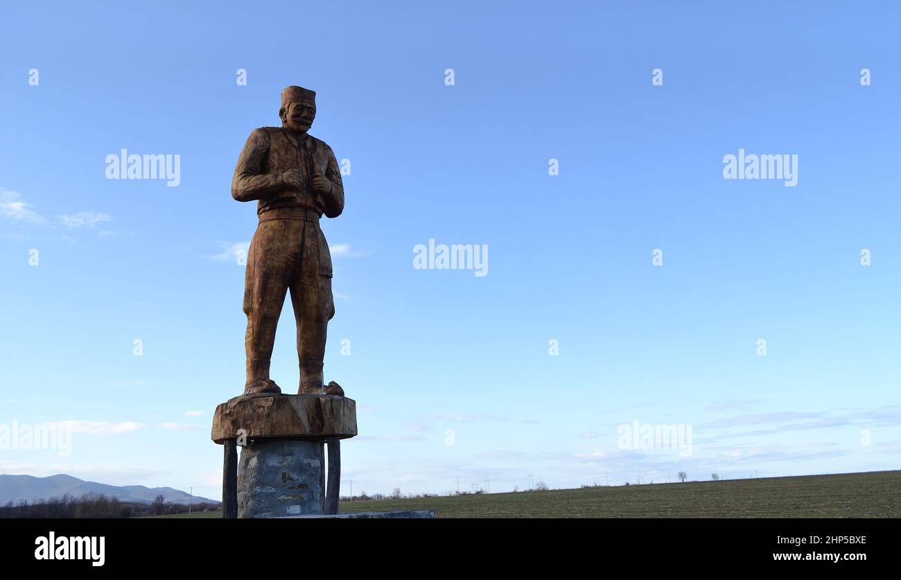 Wooden statue of Serbian peasant dressed in traditional Serbian costume ...