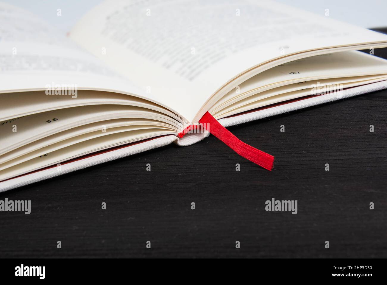 White book pages with red tape on black background Stock Photo - Alamy