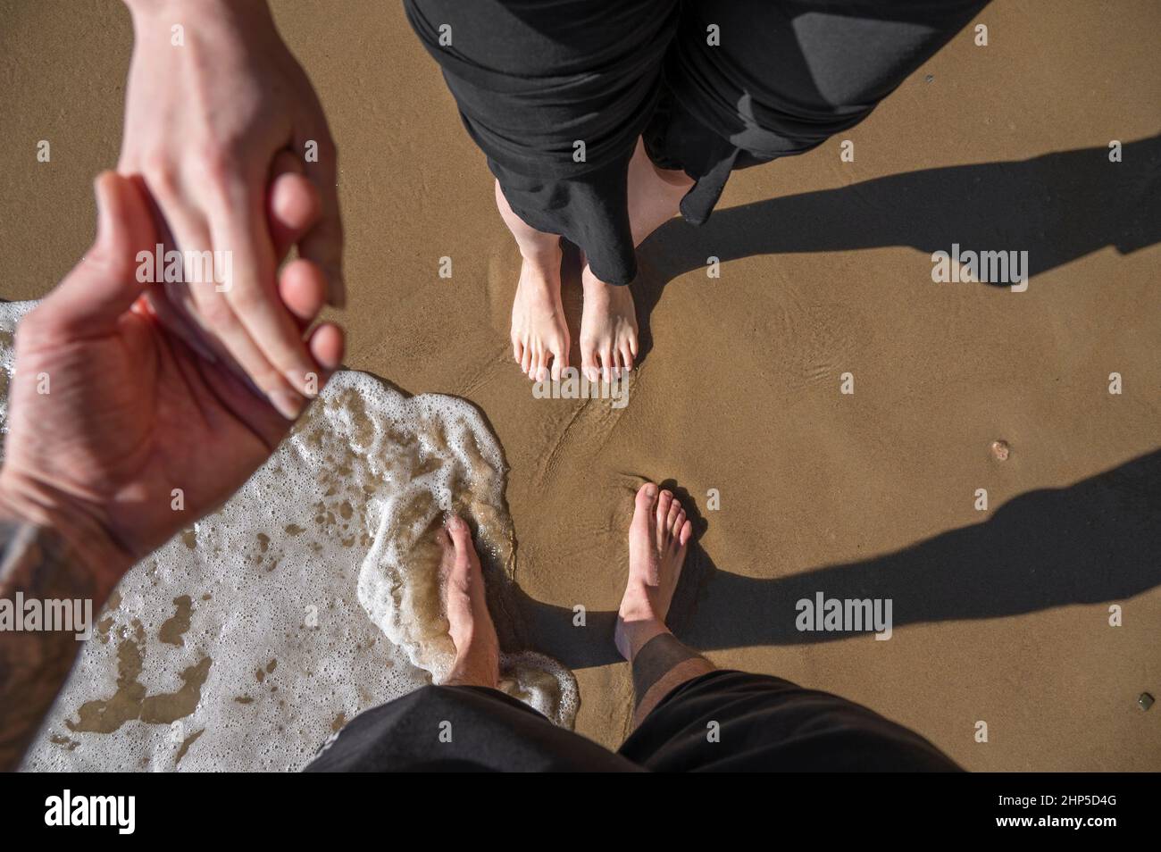 Couple together at beach hand in hand Stock Photo - Alamy