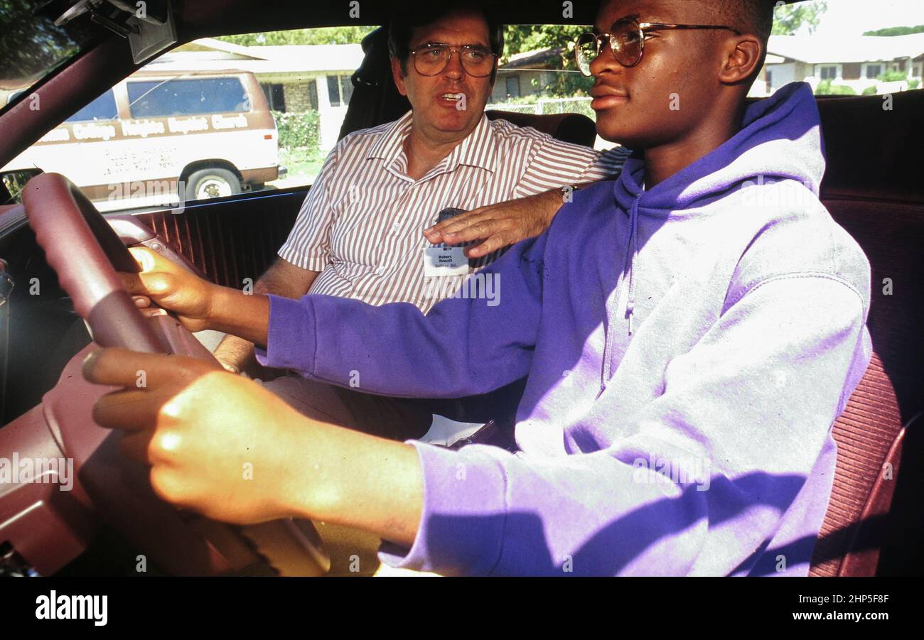 Austin, Texas USA,1993: Black teen boy takes the wheel with instructor ...
