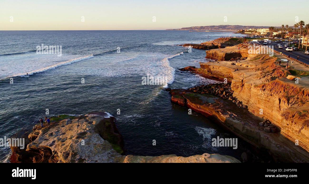 Aerial view of people watching golden sunset at Sunset Cliffs Natural ...