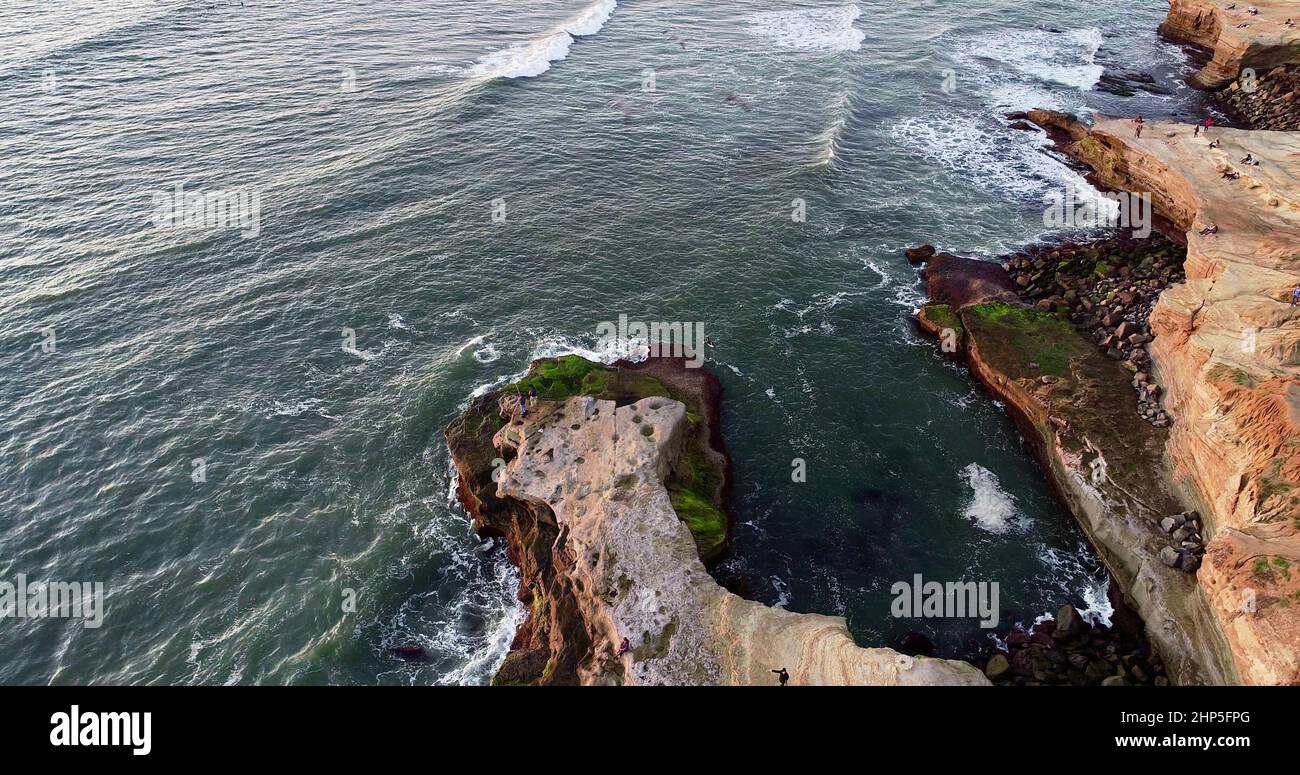 Aerial view of people watching golden sunset at Sunset Cliffs Natural ...