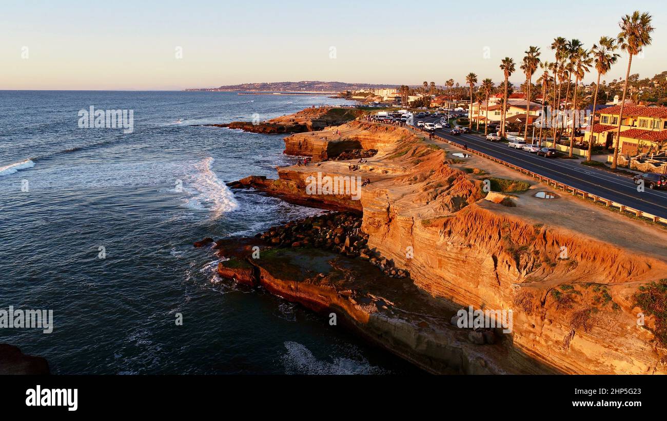 Aerial view of people watching golden sunset at Sunset Cliffs Natural ...