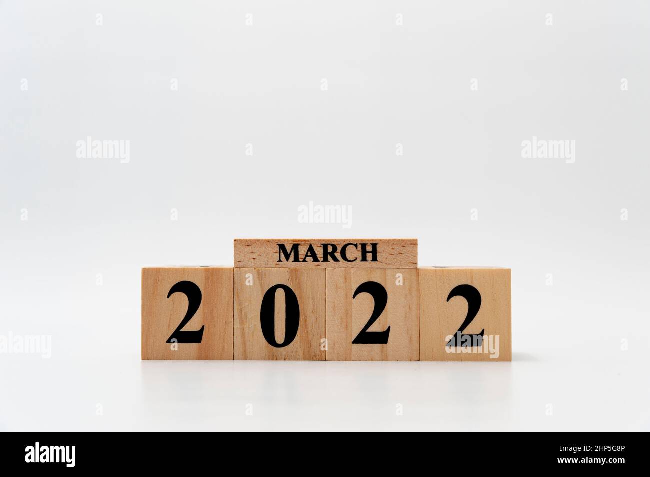 March 2022 written on wooden blocks isolated on white background with ...