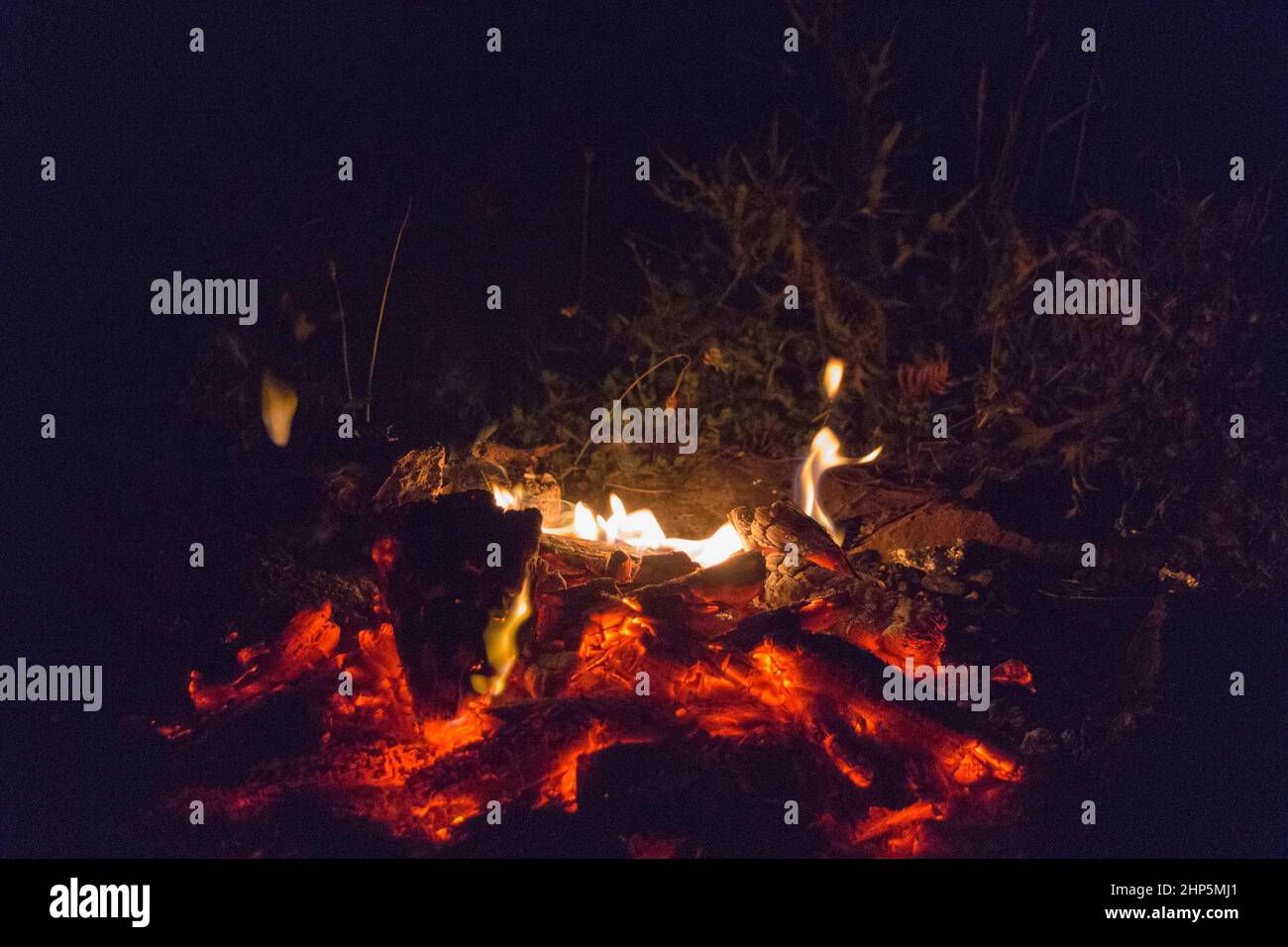 The view of a dying bonfire ready for snuffing on black background ...