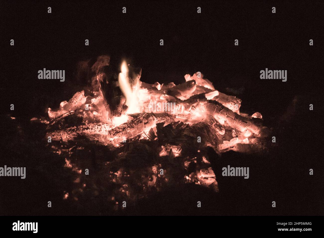 The view of a dying bonfire ready for snuffing on black background ...